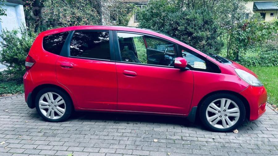Red Honda Jazz 2012 in Riga, with an engine capacity of 1.40 L and mileage of 165 thousand km for 3390 €, photo 1 on AUTOMOTO.COM.LV
